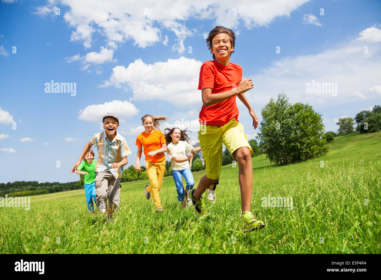 Happy children running together in the field Stock Photo - Alamy