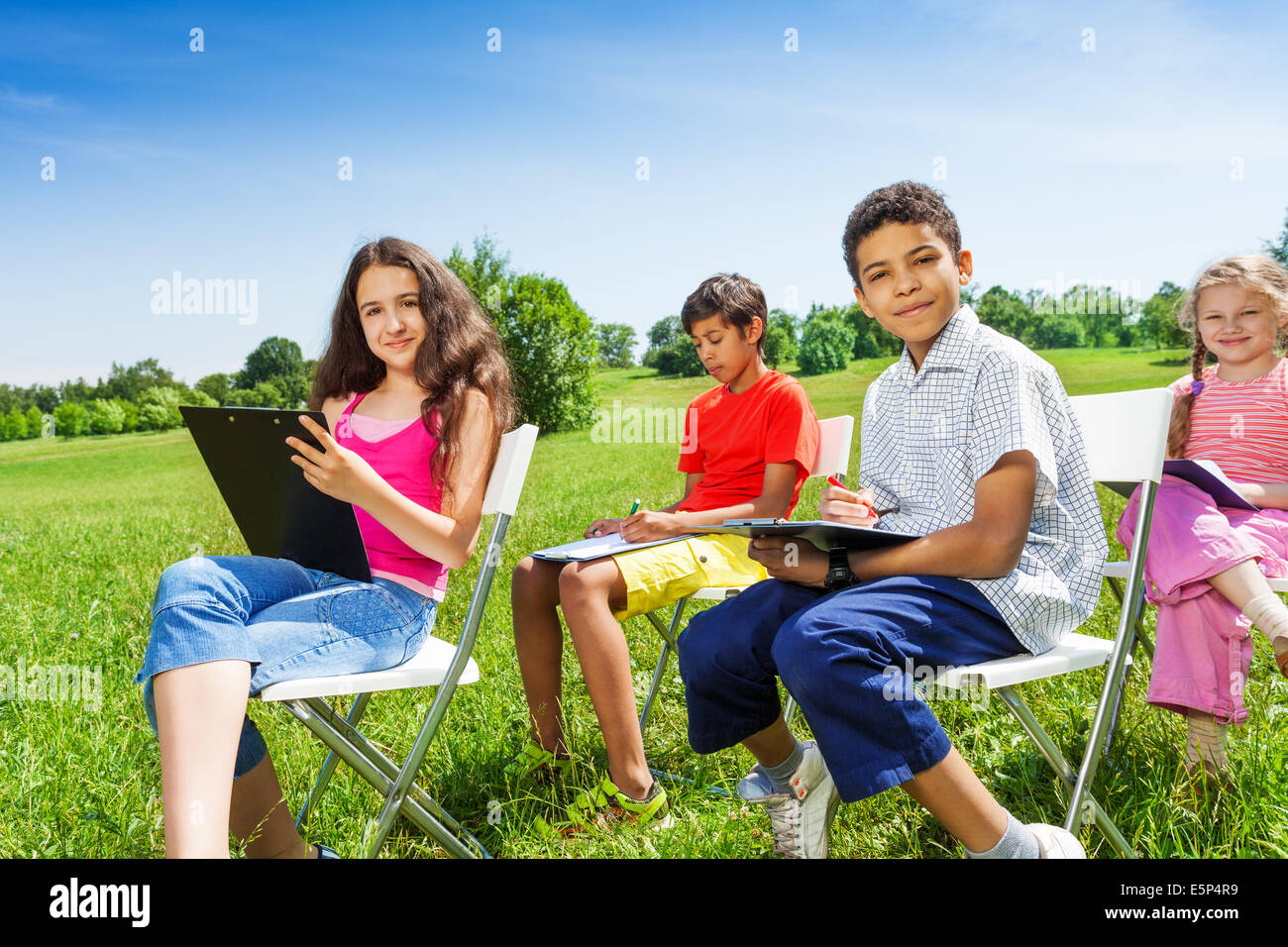 Kids drawing on clipboards together outside Stock Photo - Alamy