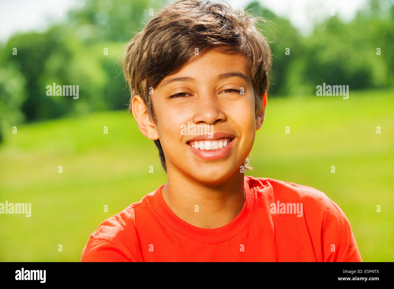 Brunet smiling boy in red T-shirt portrait Stock Photo - Alamy