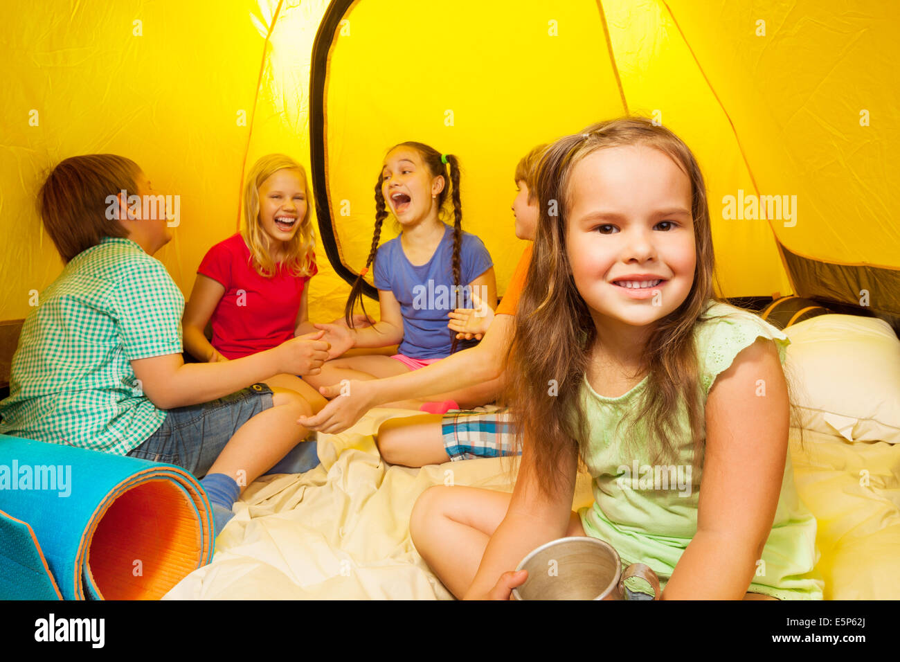 Five kids sit inside a yellow tent Stock Photo - Alamy