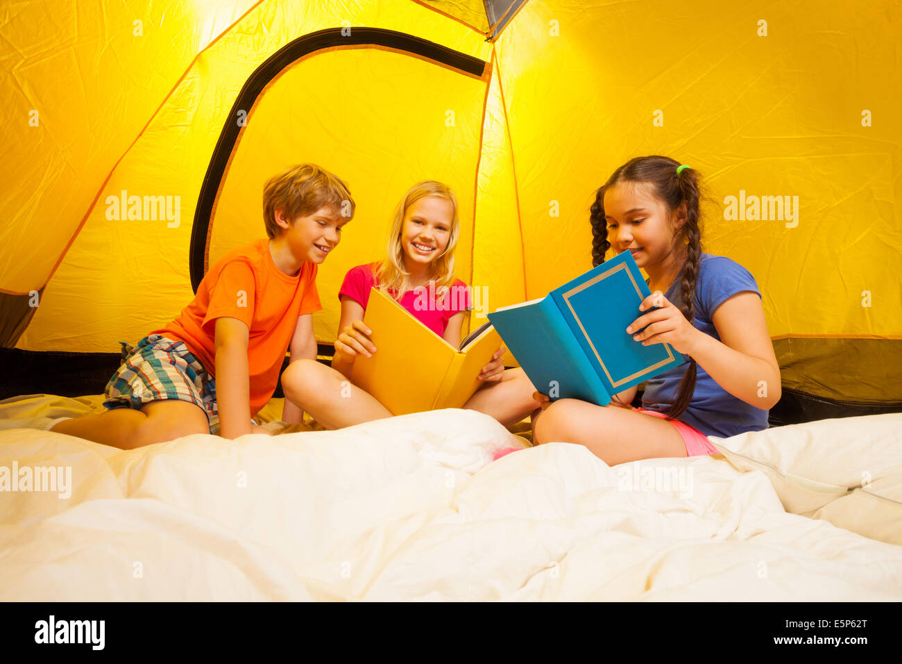 Three kids reading books in a tent Stock Photo - Alamy
