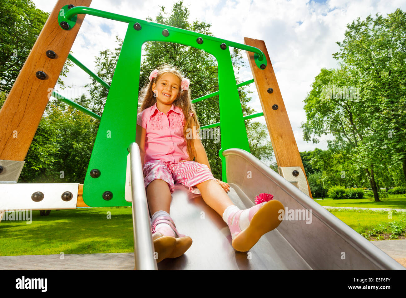 Pretty small girl on chute sitting and smiling Stock Photo - Alamy