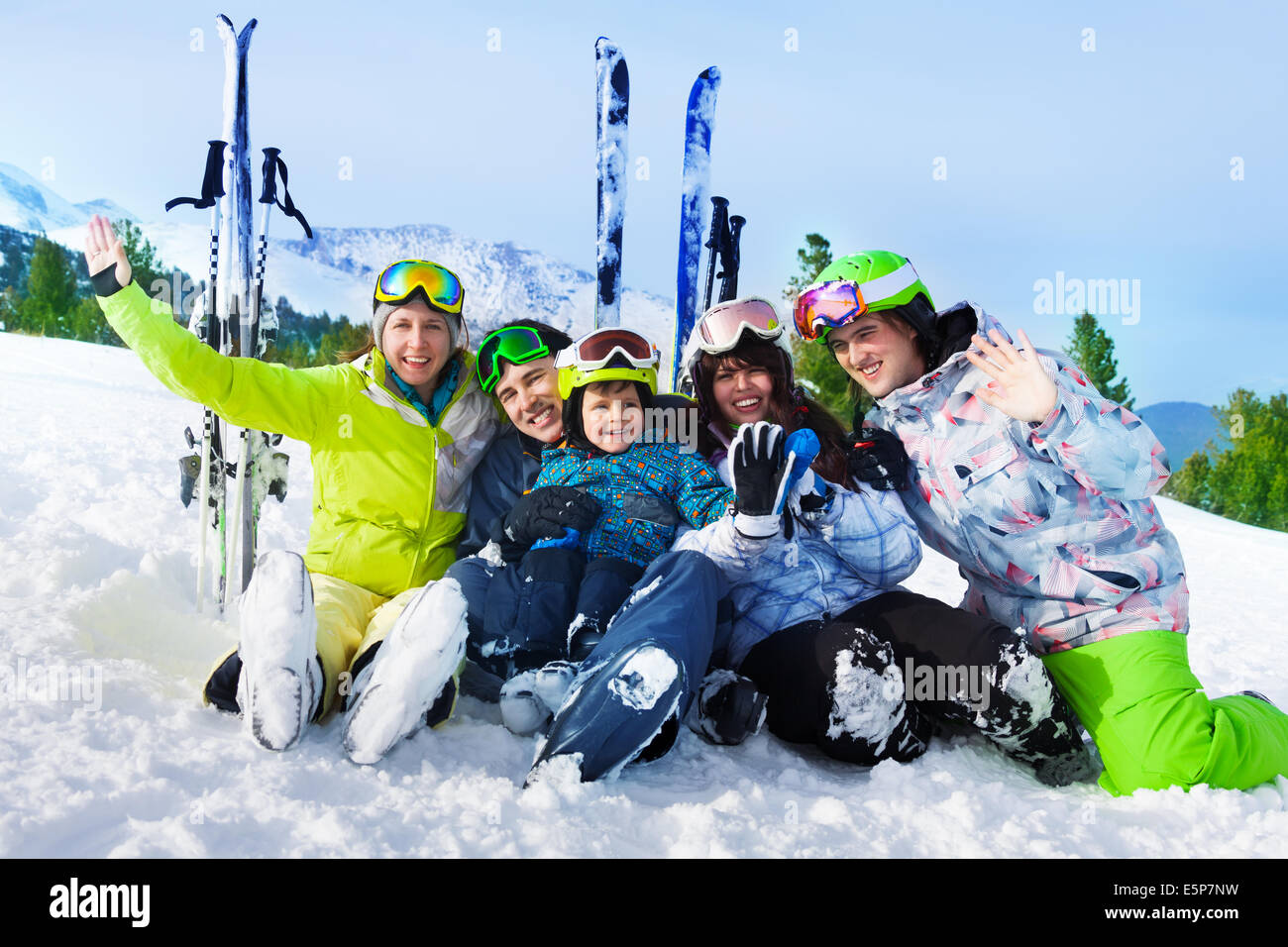 Smiling friends after skiing sit on snow together Stock Photo - Alamy