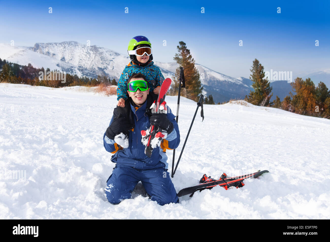 Smiling father in ski mask with son on shoulders Stock Photo - Alamy