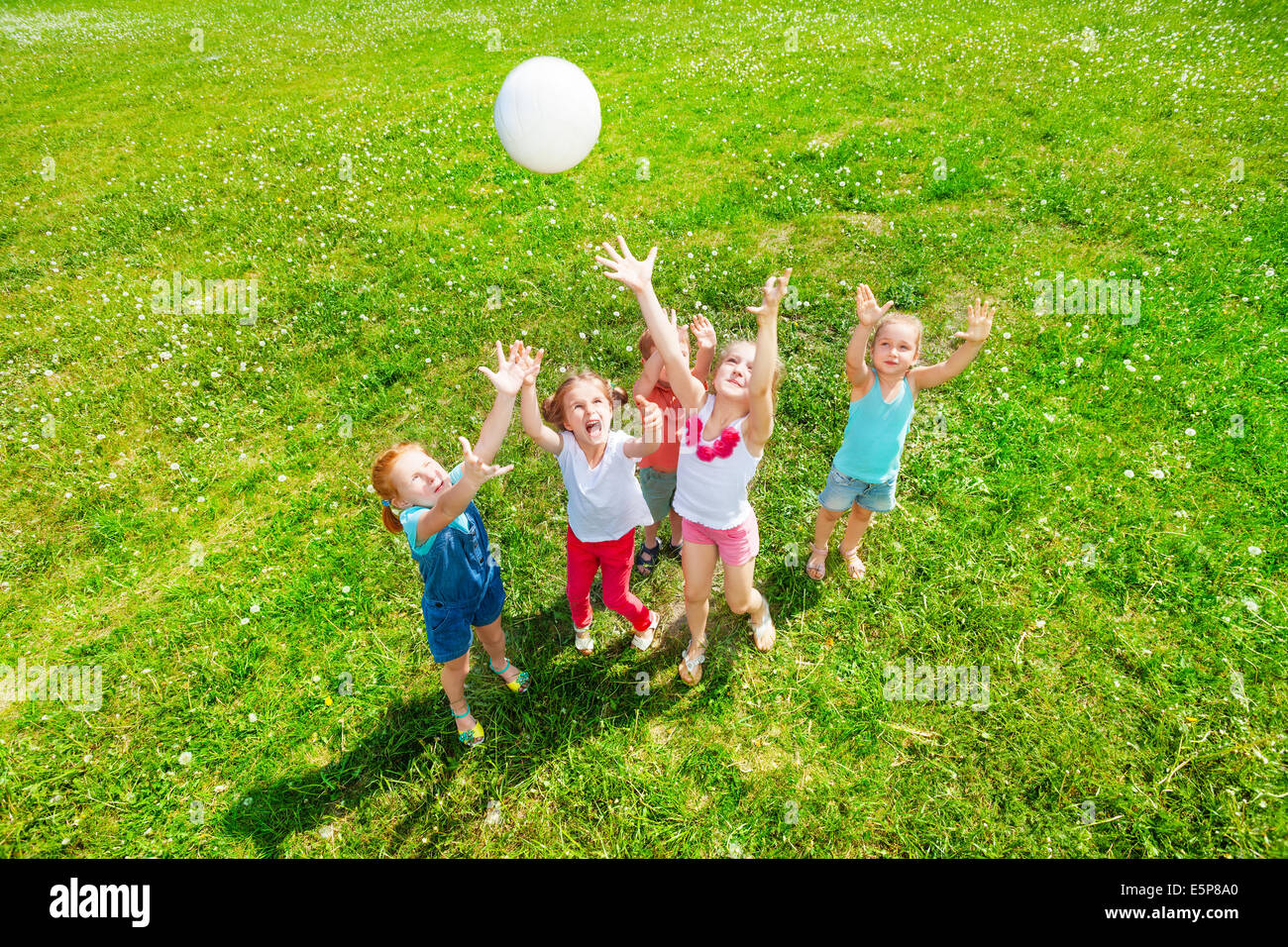 Kids playing ball on a meadow Stock Photo - Alamy