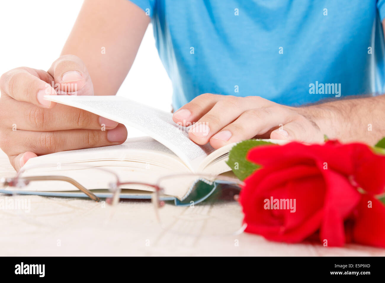young man with his hands holding open book and leafing through pages ...
