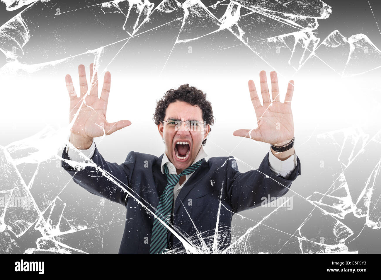 angry and shocked businessman holding broken glass wall, looking to ...
