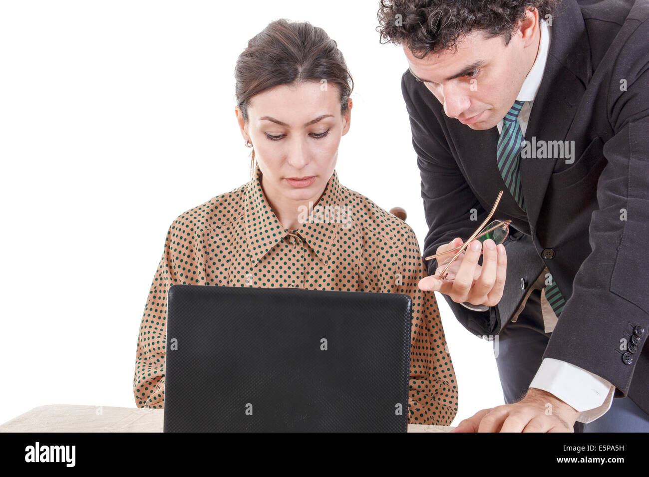 Boss and worried secretary working together on laptop computer, showing ...