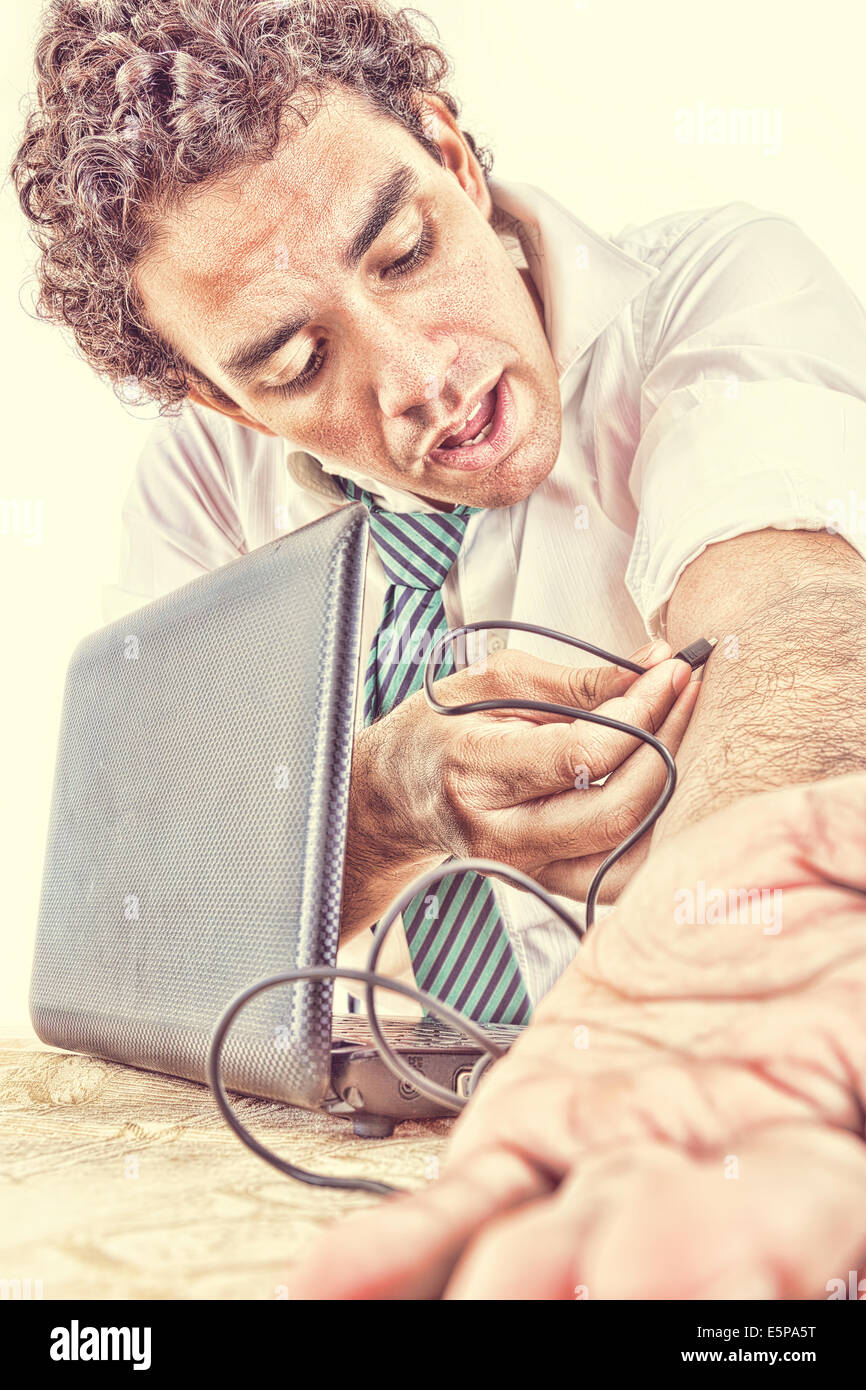 business man in suit addicted to internet put USB cable from laptop ...
