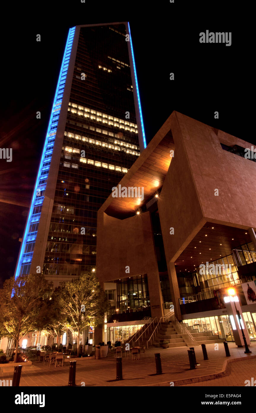 A skyscraper with lights on the building soars in night sky next to a ...