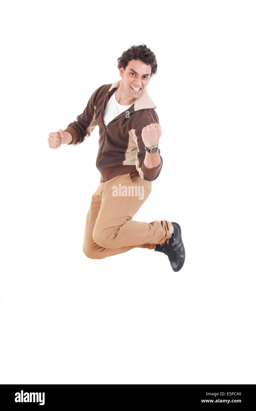 Portrait of ecstatic casual young man jumping in the air with hands ...