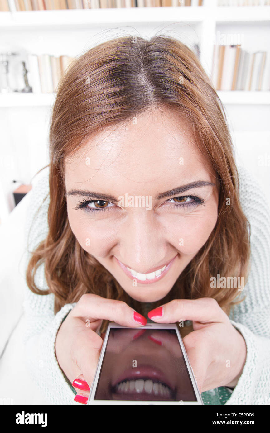 young woman with crazy face expression is trying to spite insidiously ...