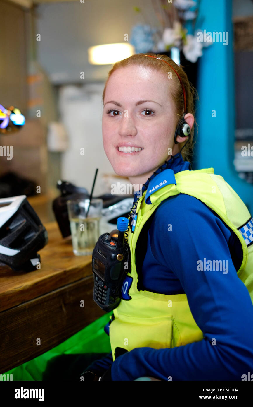 a female police community support officer smiling in a bar drinking ...