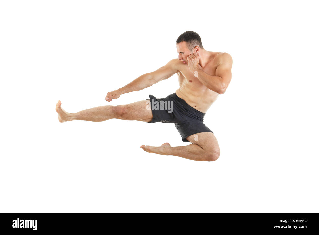 Athletic boxer fighter performing a flying side kick isolated on white ...