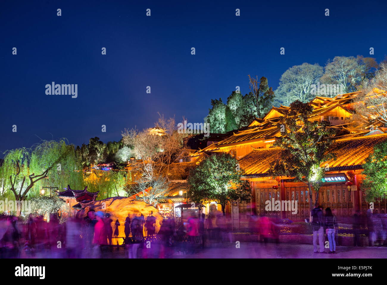 Colourfully illuminated traditional architecture and trees in the old ...