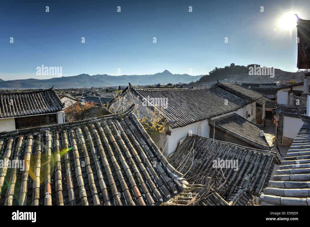 The roofs of Lijiang Old Town, UNESCO Site, with Lion Hill silhouetted ...
