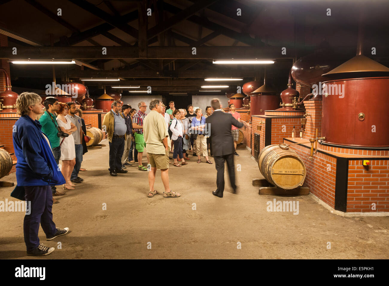 Tour guide explaining to visitors the distilling process at Hennessy ...