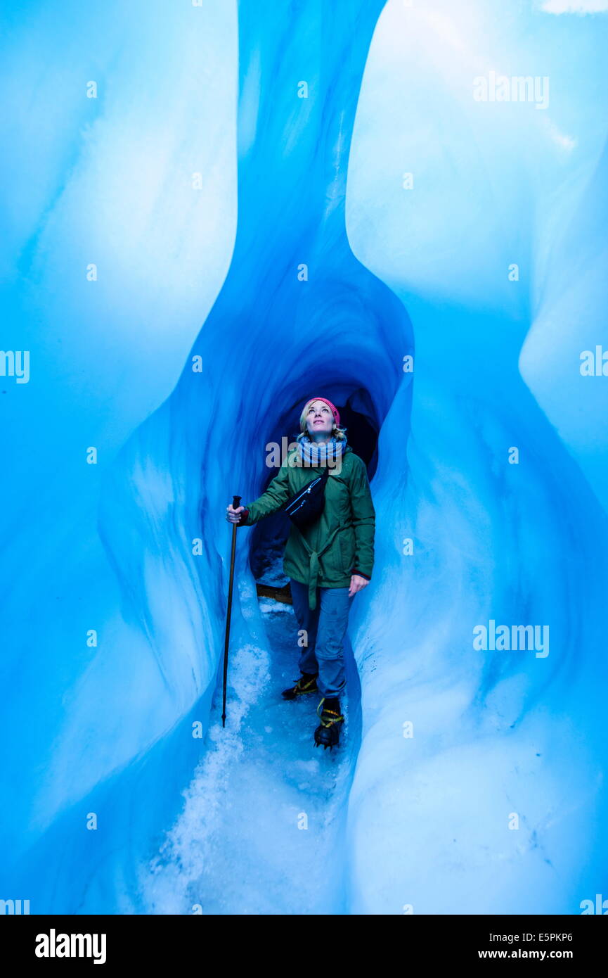 Woman standing in an ice cave, Fox Glacier, Westland Tai Poutini ...