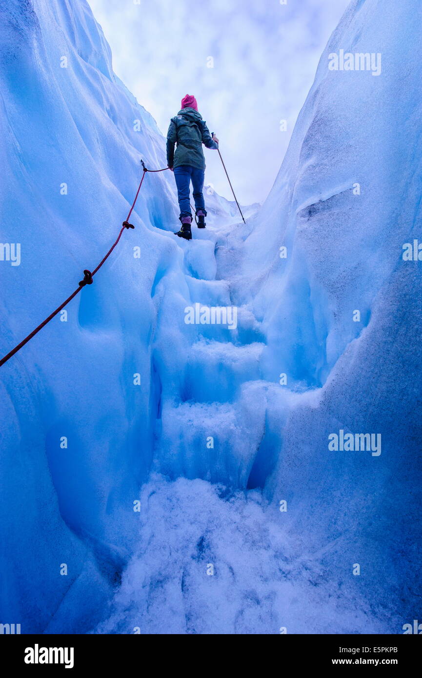 Woman walking steps out of ice cave in fox glacier hi-res stock ...