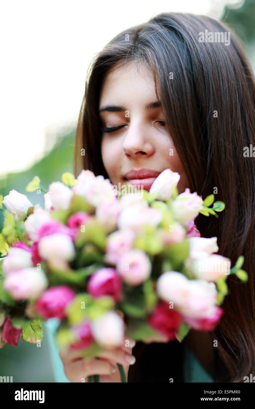 Portrait of a young beautiful woman smelling flowers Stock Photo - Alamy
