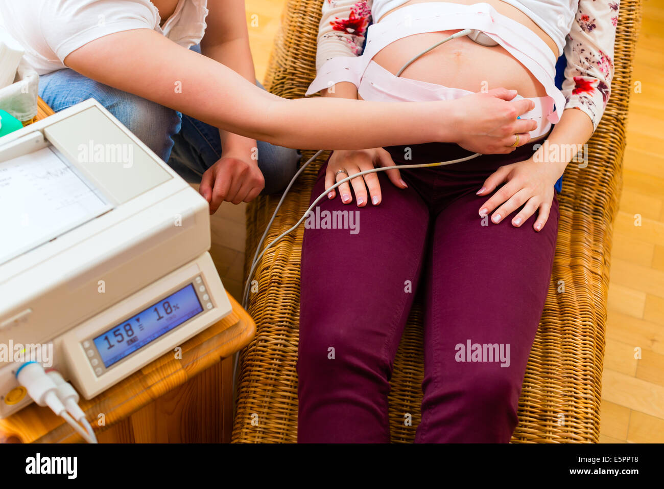 Midwife exanimating belly of pregnant woman with CTG scanning in ...