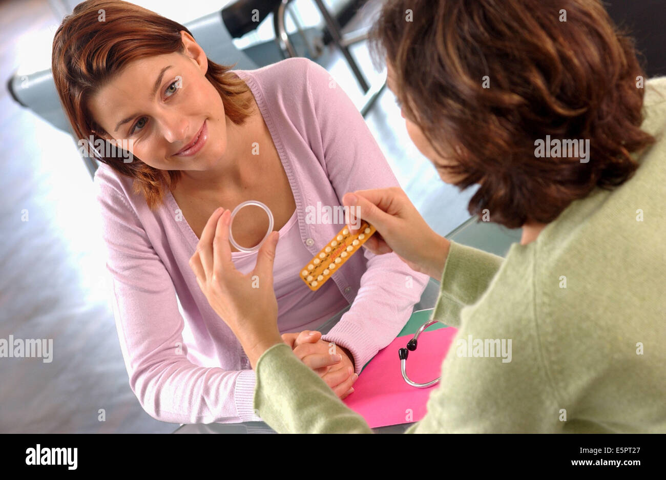 A gynecologist explains a patient the different contraceptives : pills ...
