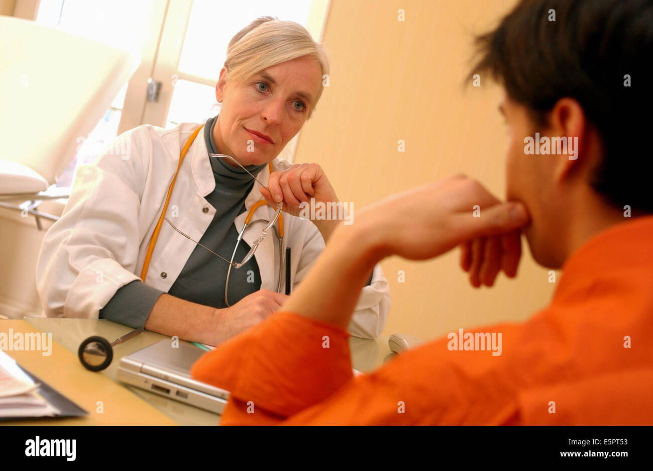 General practitioner discussing with a patient during consultation ...