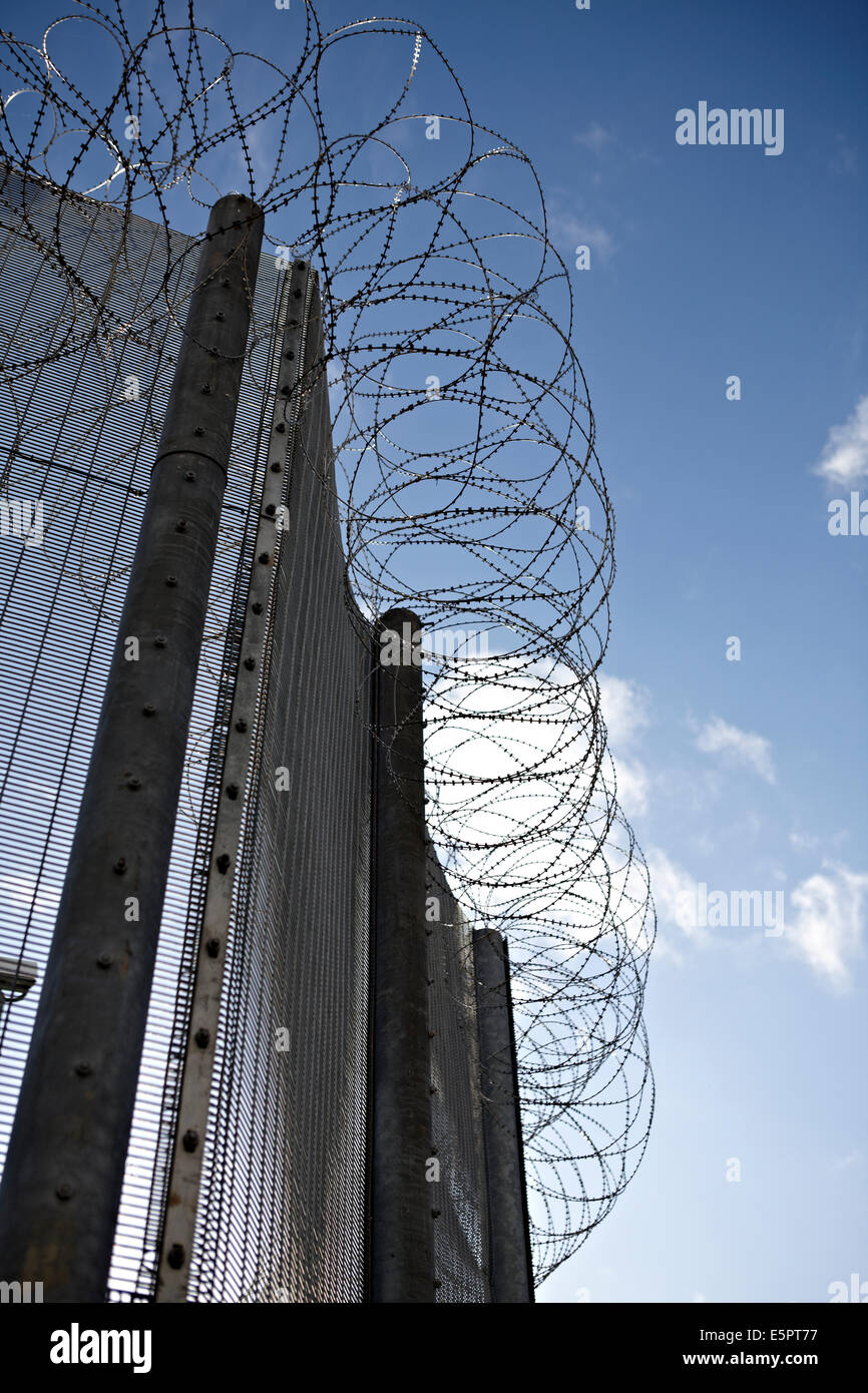 High security fencing, razor and barbed wire around the perimeter of a ...