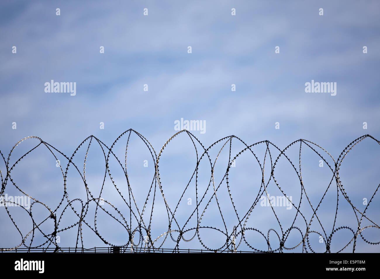 High security fencing, razor and barbed wire around the perimeter of a ...