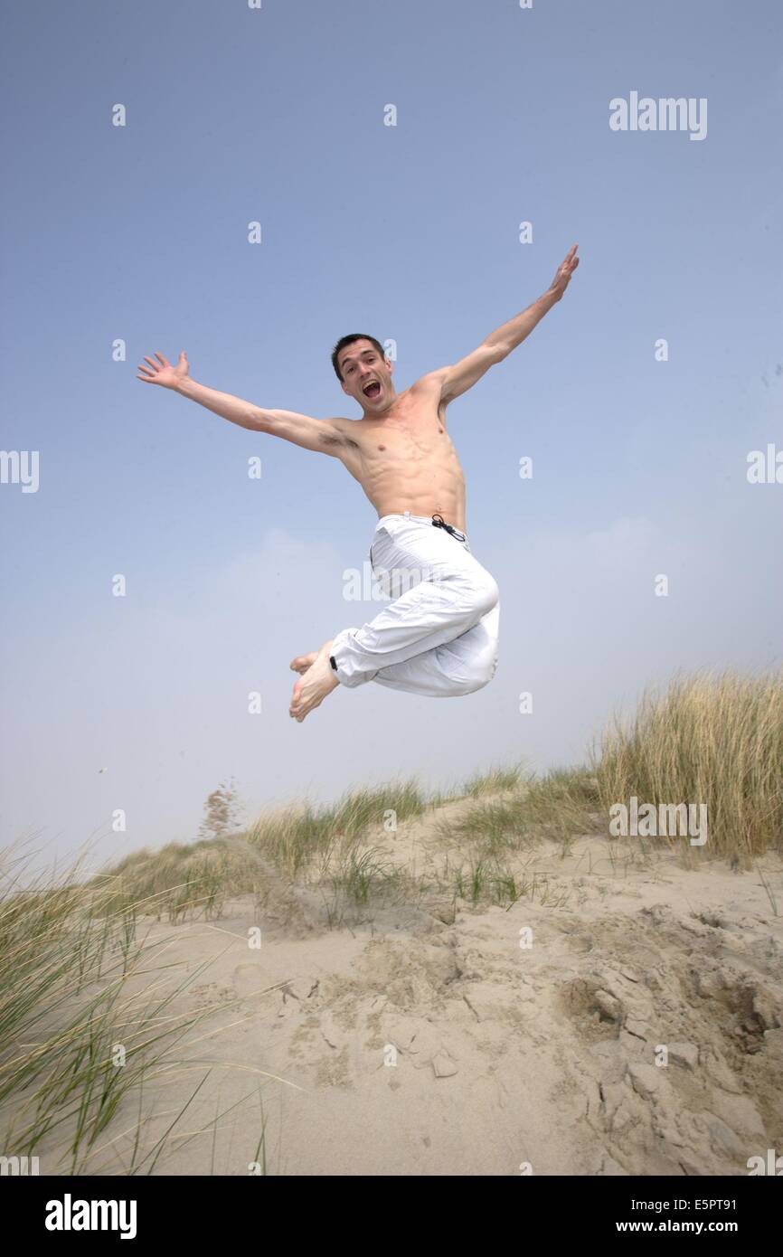 Man jumping in sand dunes Stock Photo - Alamy