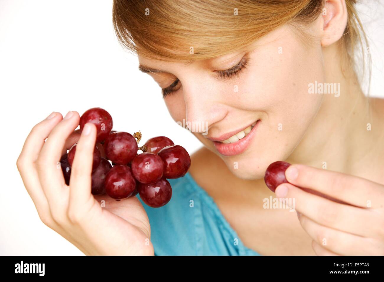 Woman eating grape Stock Photo - Alamy