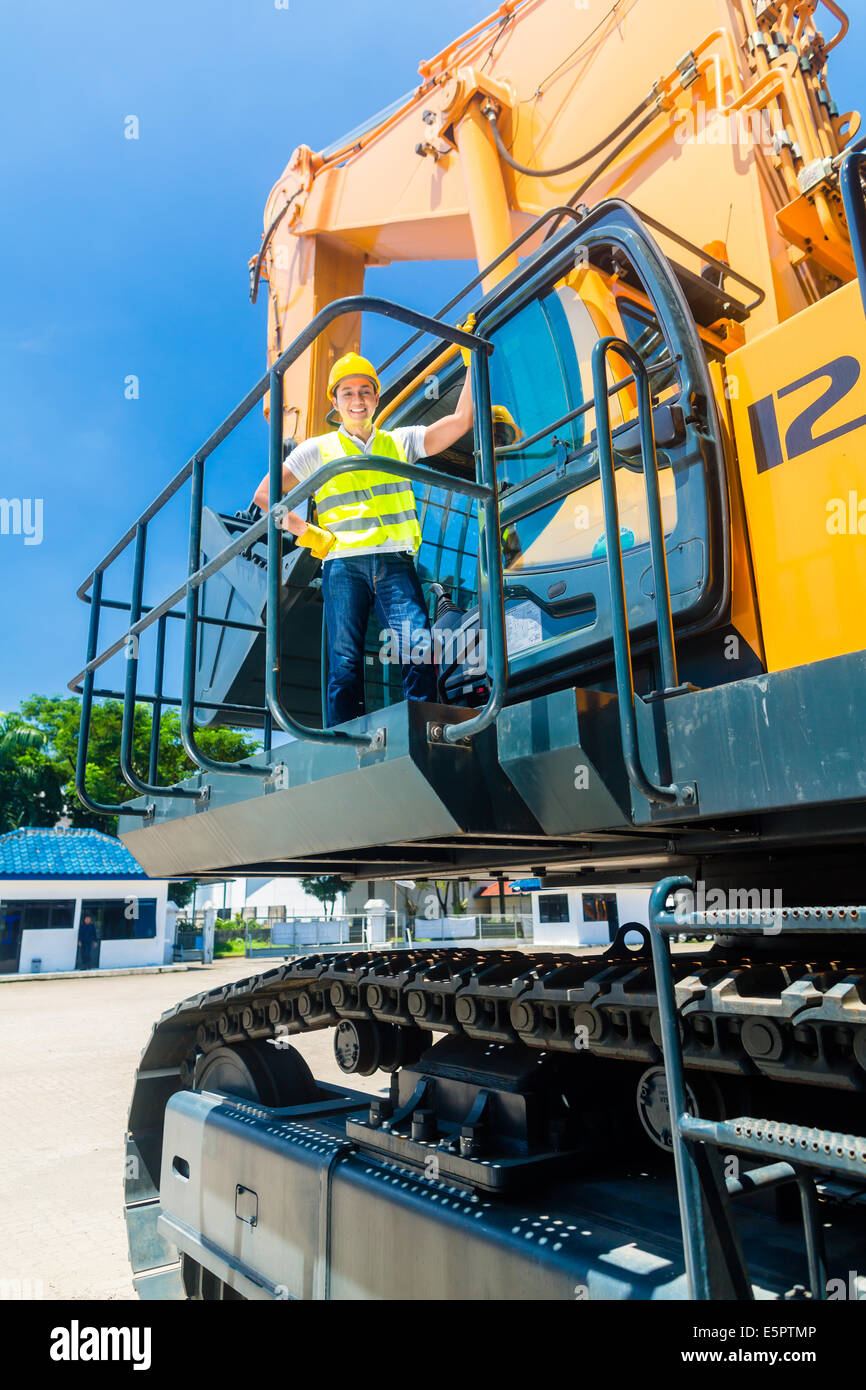 Asian driver standing on construction machinery on building site Stock ...