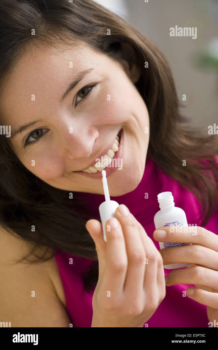 Woman applying a bleaching gel on her teeth Stock Photo - Alamy
