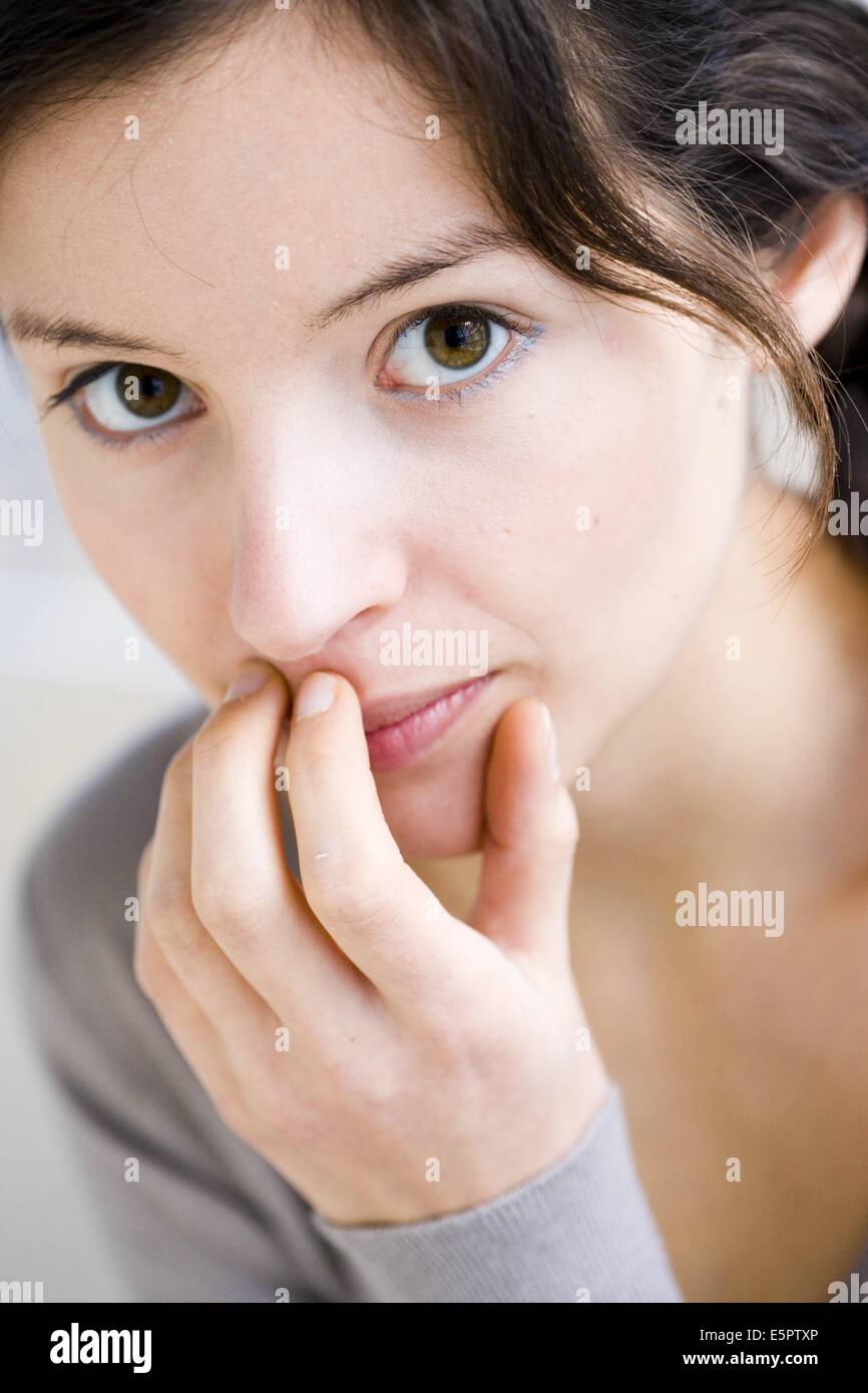 Young woman looking anguished or shy Stock Photo - Alamy