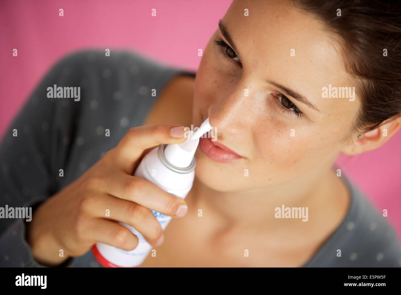 Woman using a sterile sea water spray Stock Photo - Alamy
