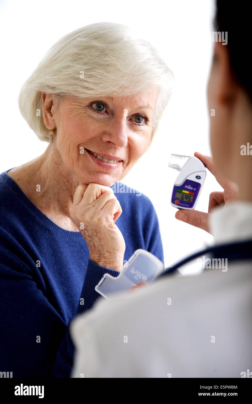 Doctor explaining a female patient the use of a PIKO-6, a digital peak ...