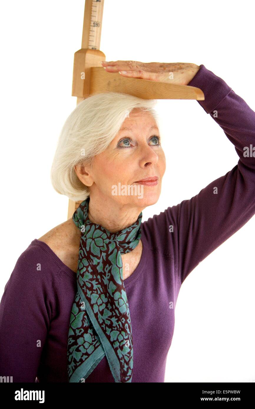 Elderly woman measuring herself with height gauge Stock Photo - Alamy