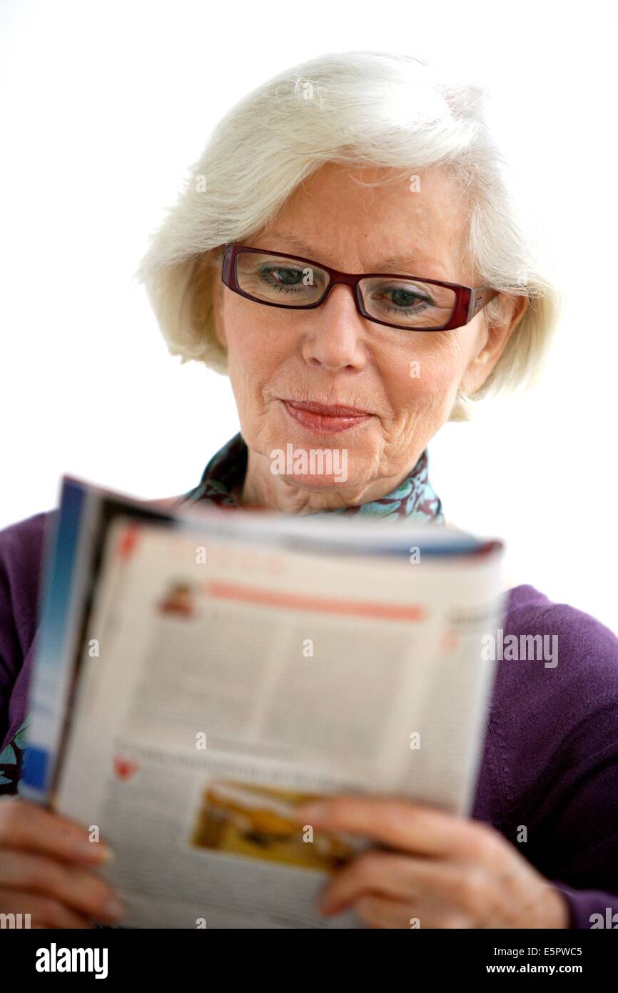 Elderly woman reading magazine Stock Photo - Alamy