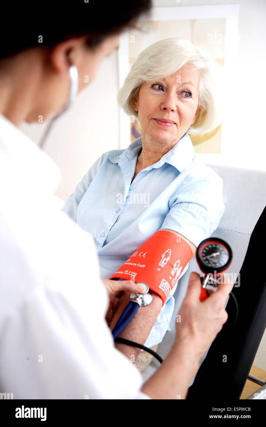 Doctor checking the blood pressure of a female patient Stock Photo - Alamy