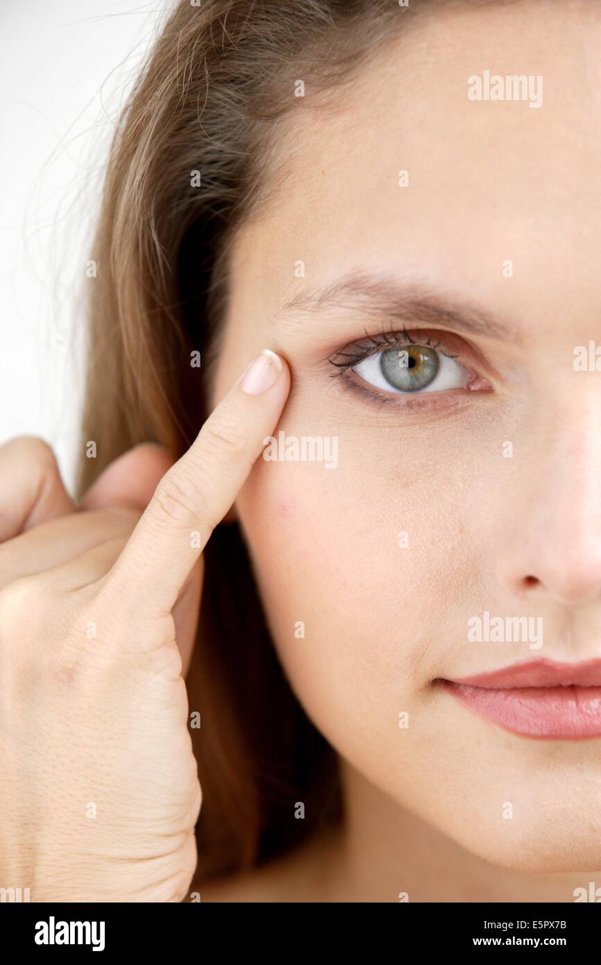 Woman with fingers on her face Stock Photo - Alamy