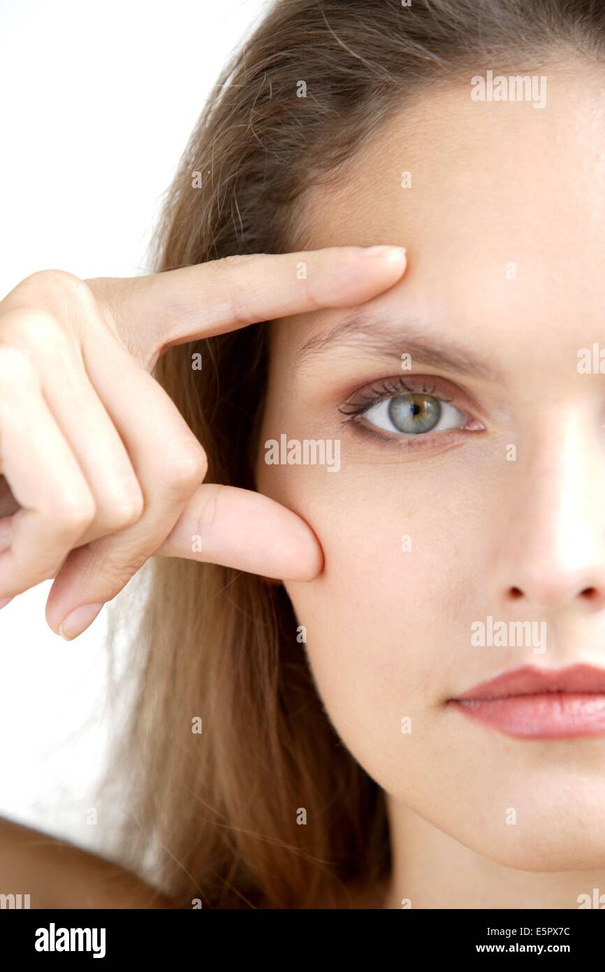 Woman with fingers on her face Stock Photo - Alamy
