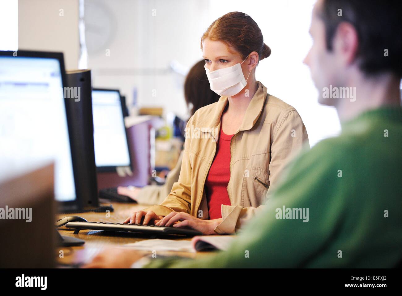 Woman wearing a protective mask at work Stock Photo - Alamy