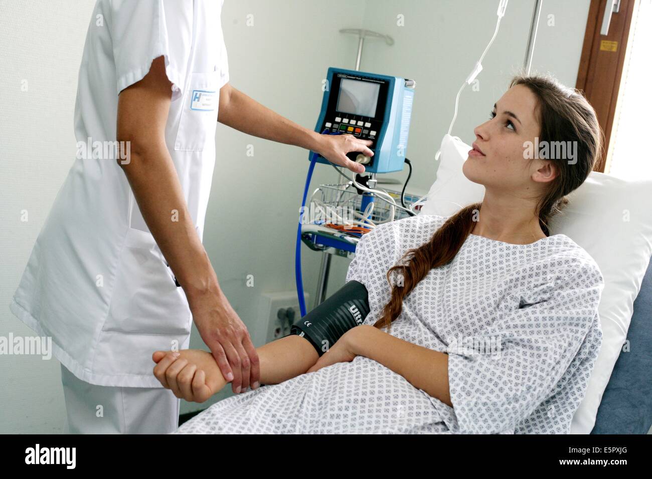 Nurse checking the blood pressure of a patient at hospital Stock Photo ...
