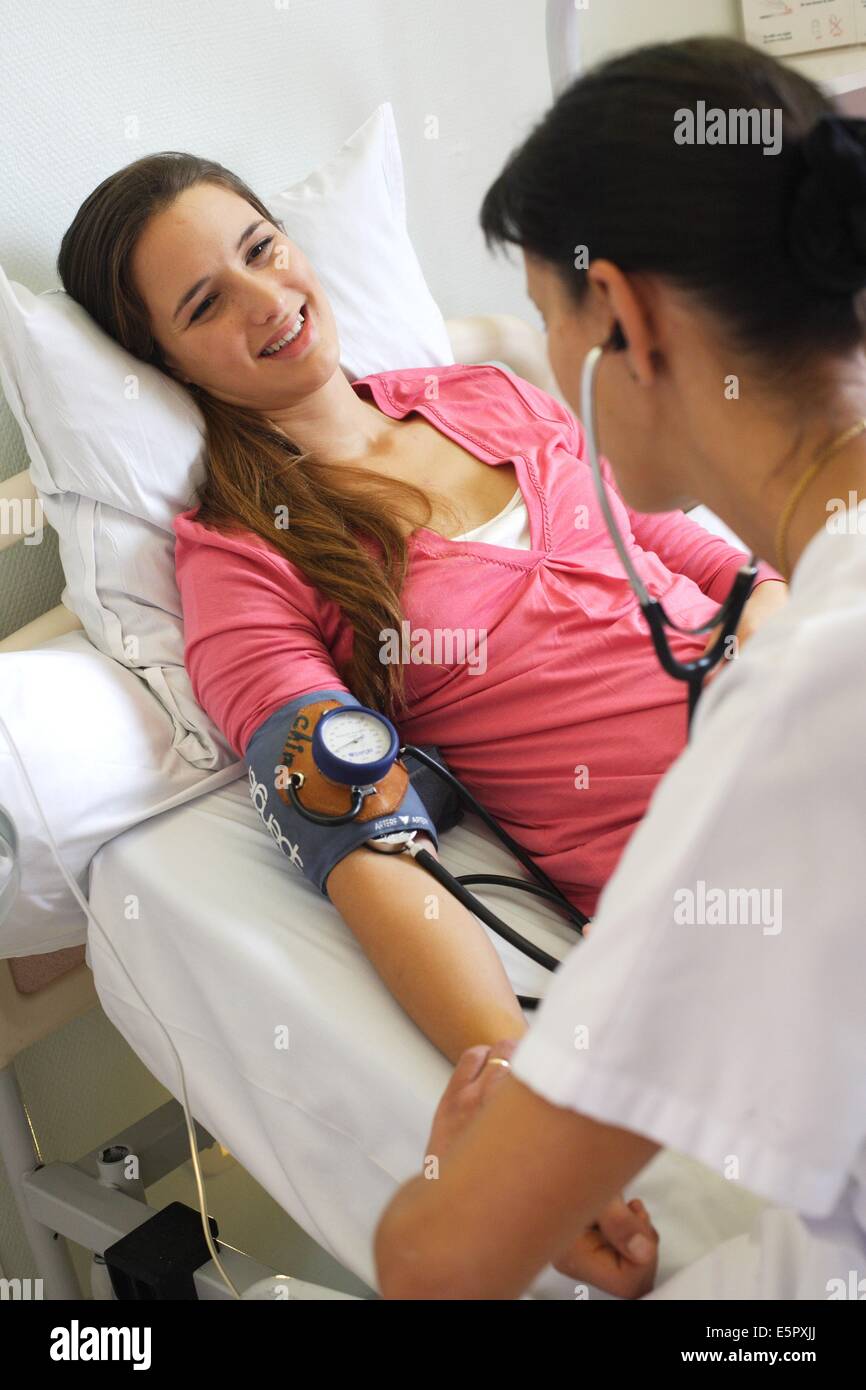 Nurse checking the blood pressure of a patient at hospital Stock Photo ...