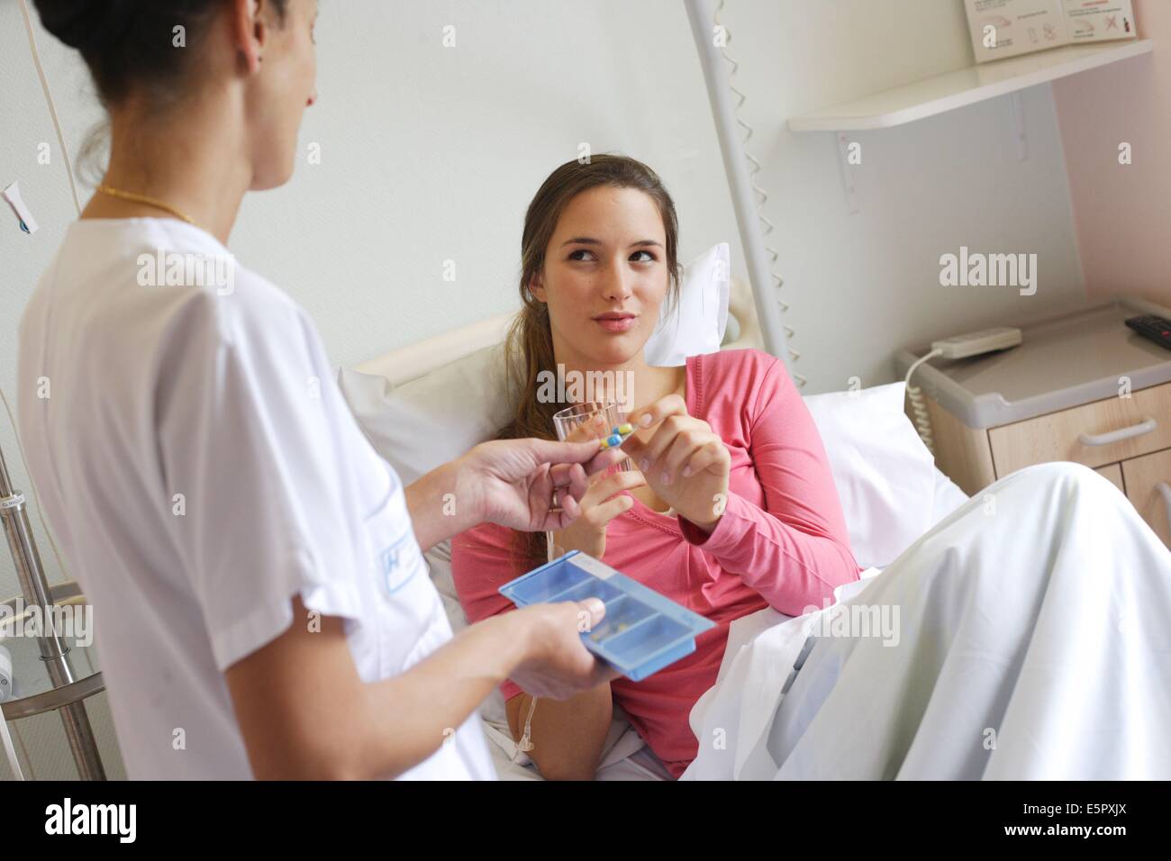 Nurse giving medication to a female patient at hospital Stock Photo - Alamy
