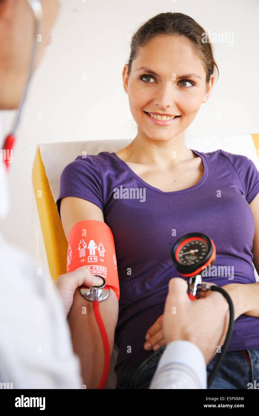 Doctor checking the blood pressure of a female patient Stock Photo - Alamy