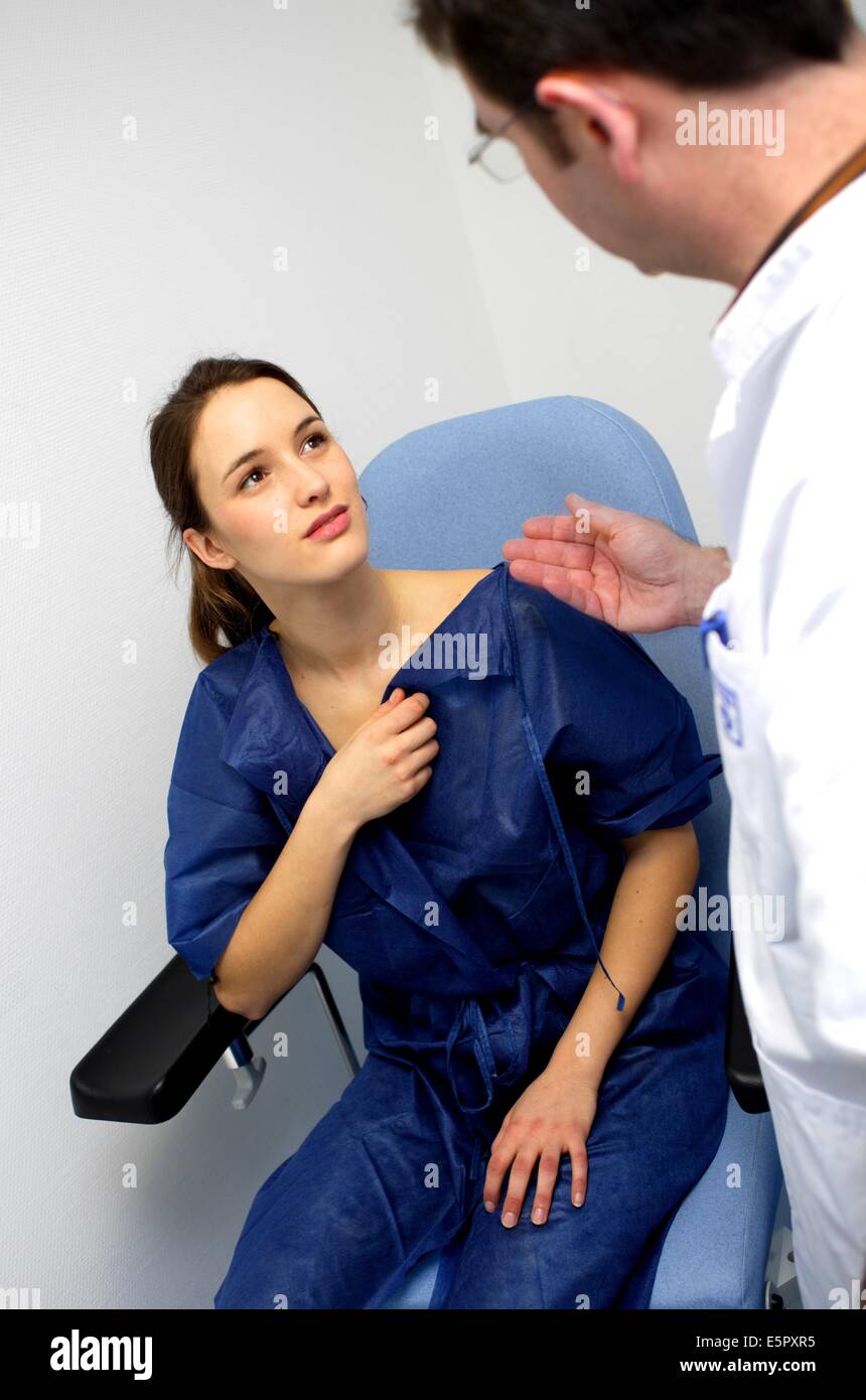 Woman putting on gown before undergoing MRI (Magnetic Resonance Imaging ...