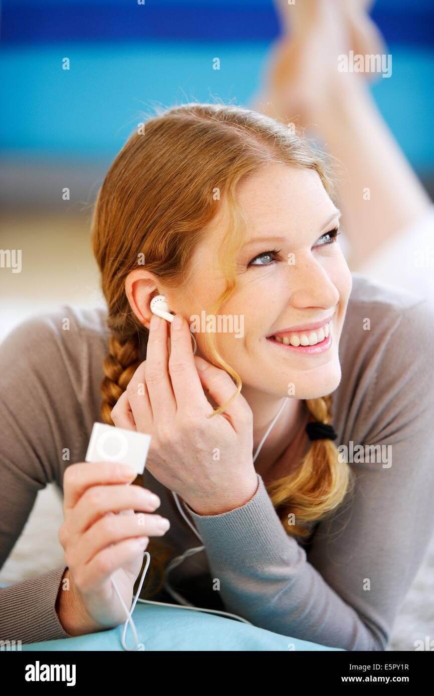 Woman listening to music with a MP3 player Stock Photo - Alamy