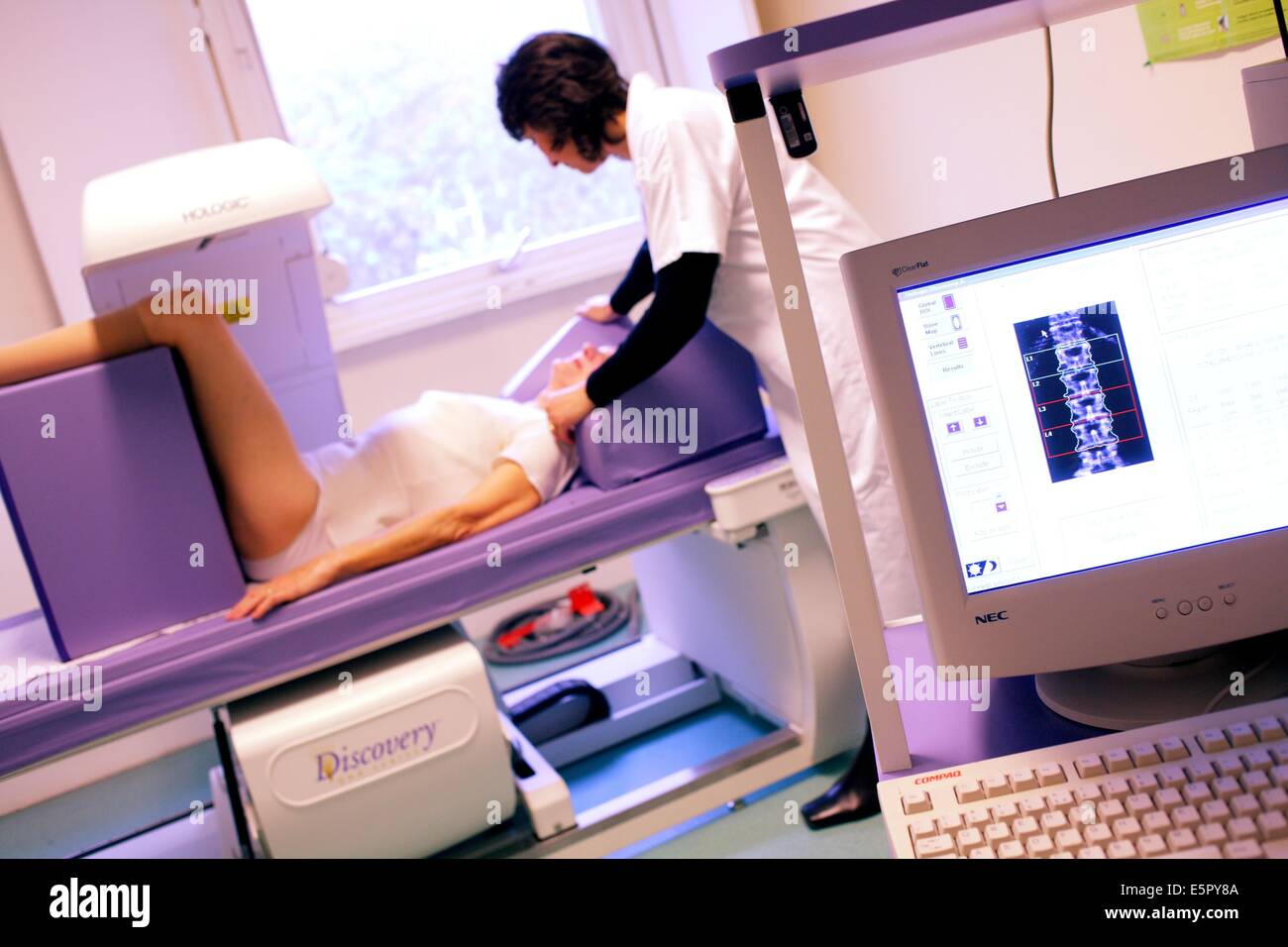 A doctor uses a bone densitometer to measure the optical density of the ...