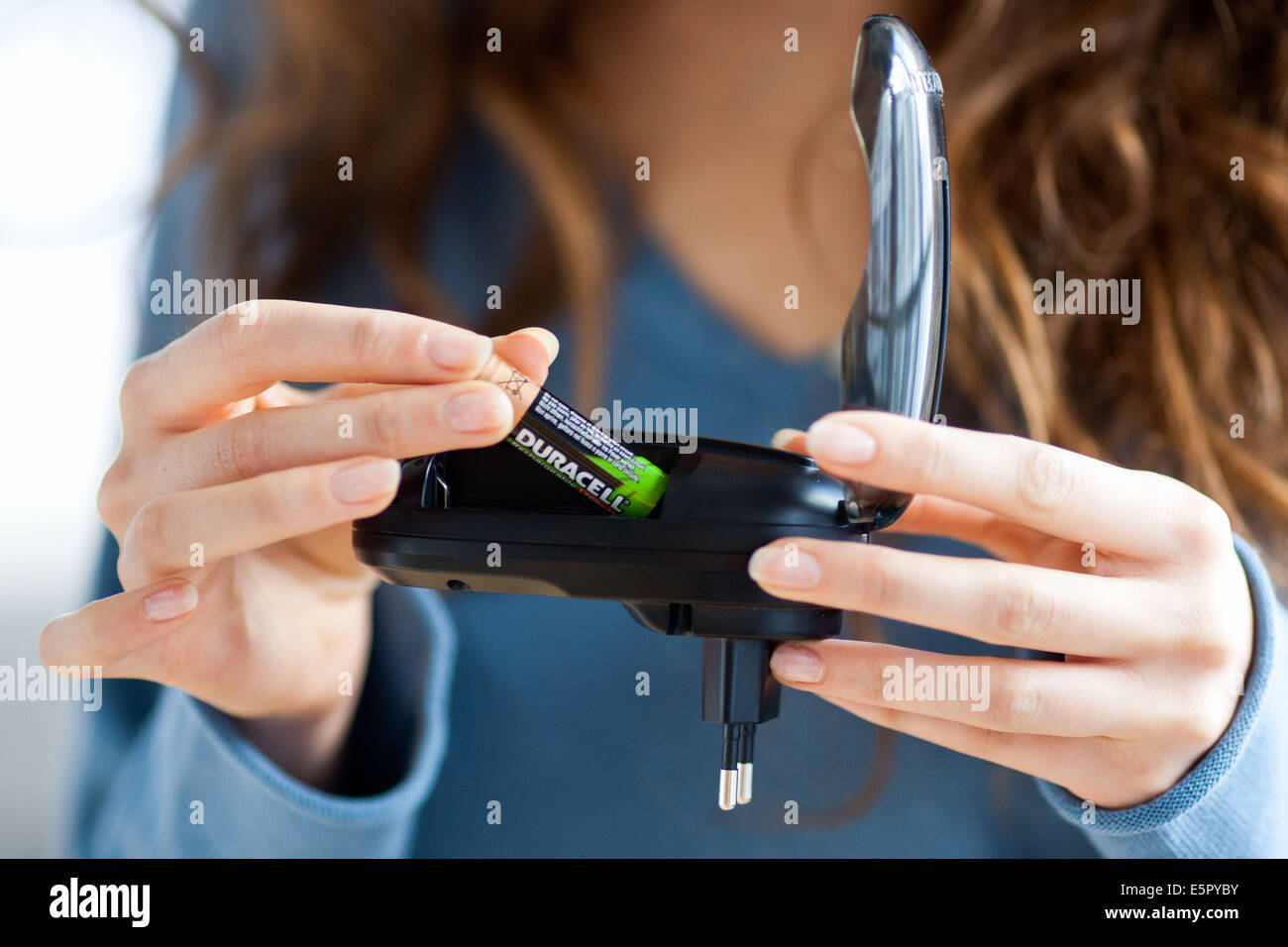 Woman using charger for rechargeable batteries Stock Photo - Alamy